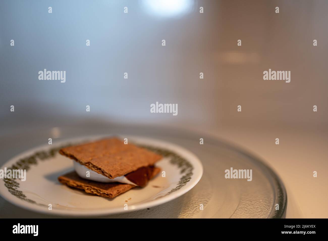 Making a smore with a marshmallow, cracker, and chocolate using a ...