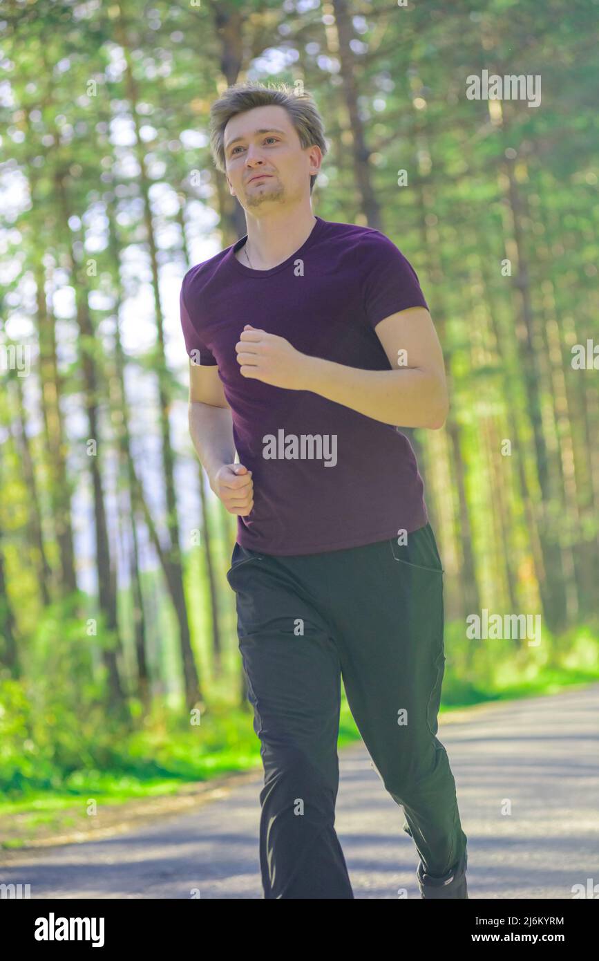 Running man jogging in city park at beautiful summer day. Sport fitness ...