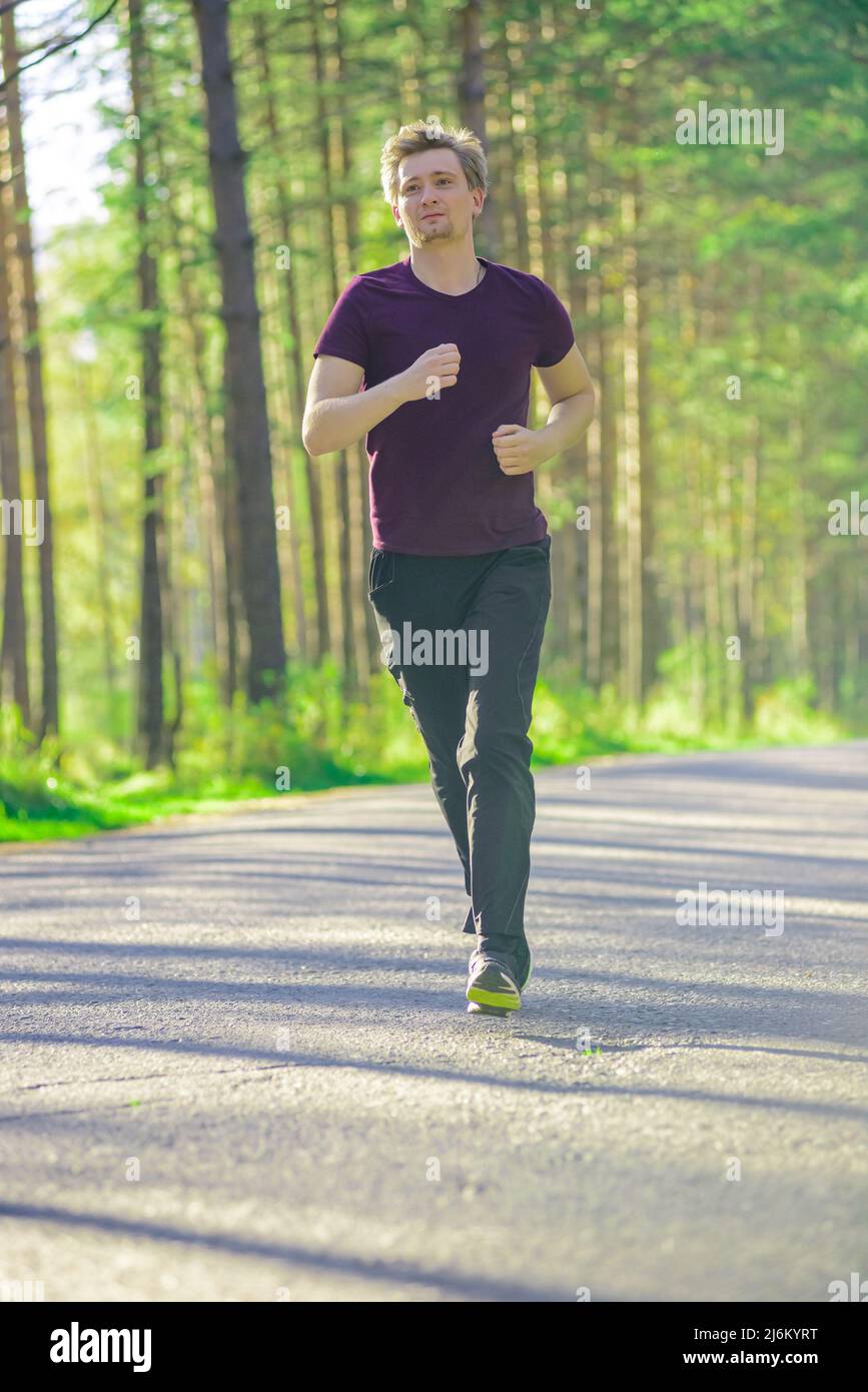 Running man jogging in city park at beautiful summer day. Sport fitness ...