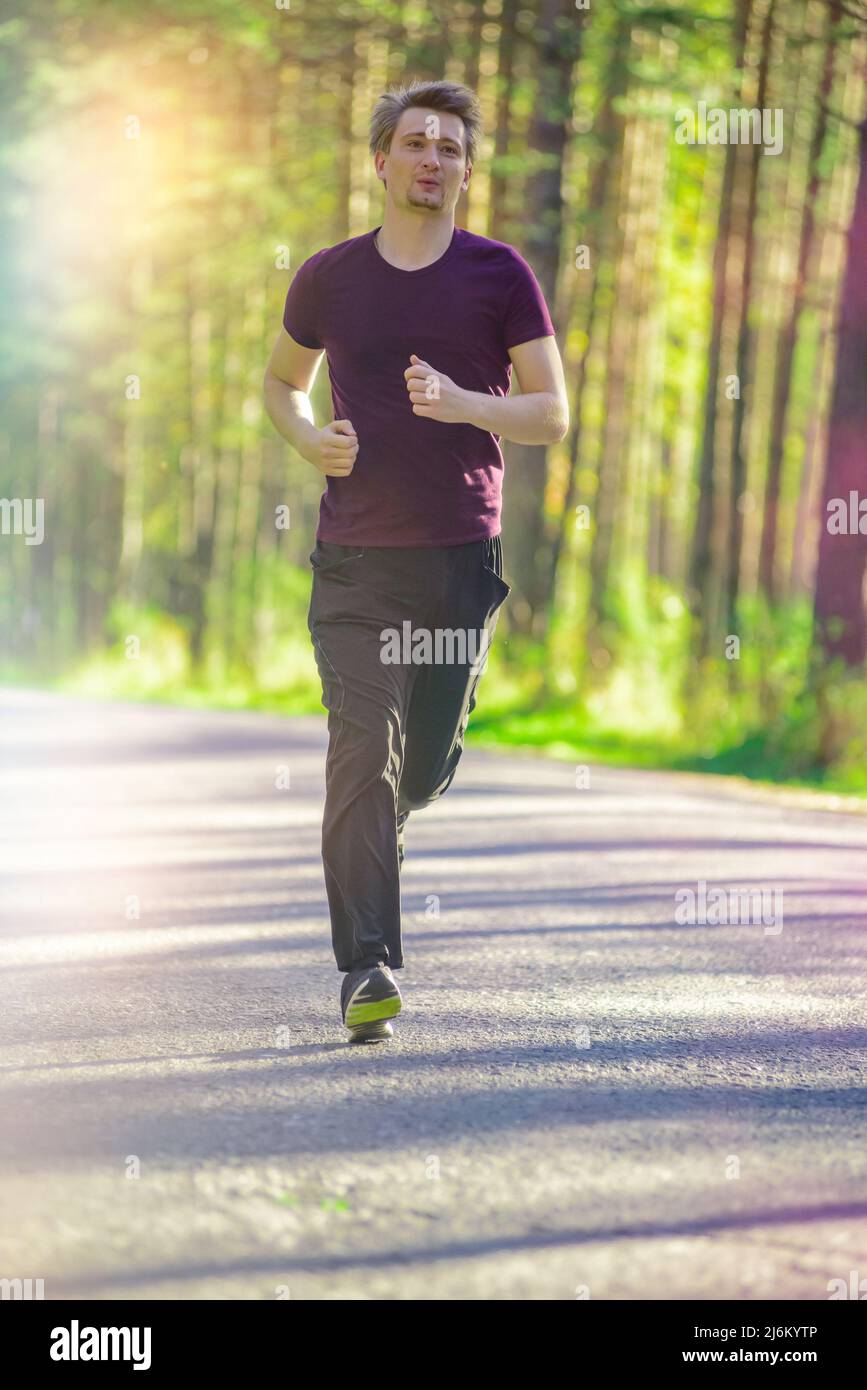 Running man jogging in city park at beautiful summer day. Sport fitness ...