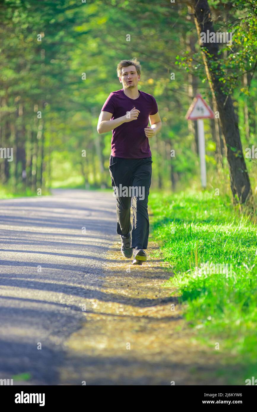 Running man jogging in city park at beautiful summer day. Sport fitness ...