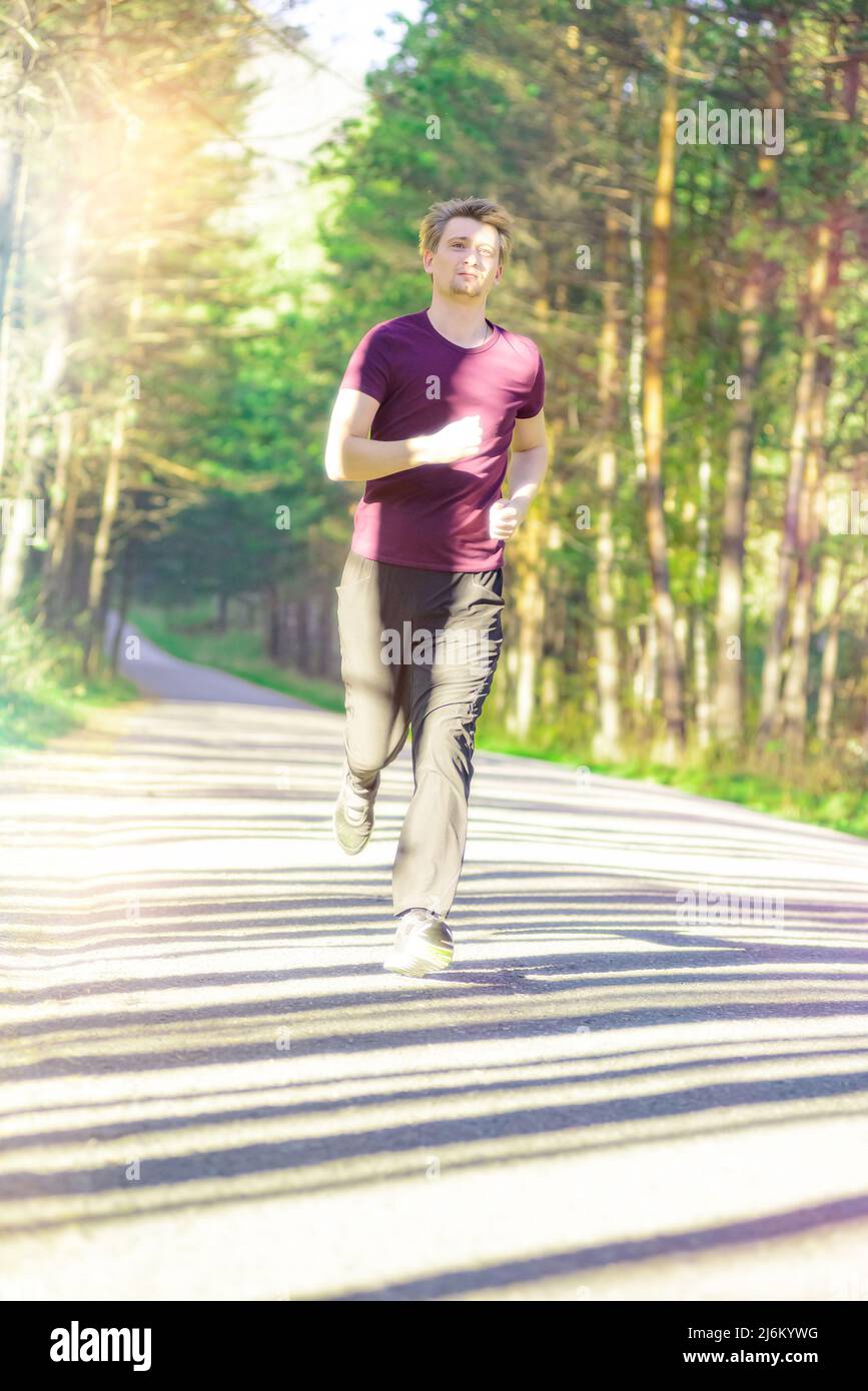 Running man jogging in city park at beautiful summer day. Sport fitness ...