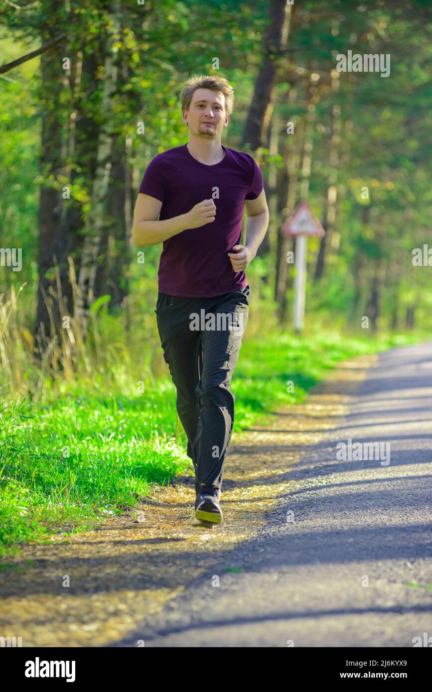 Running man jogging in city park at beautiful summer day. Sport fitness ...