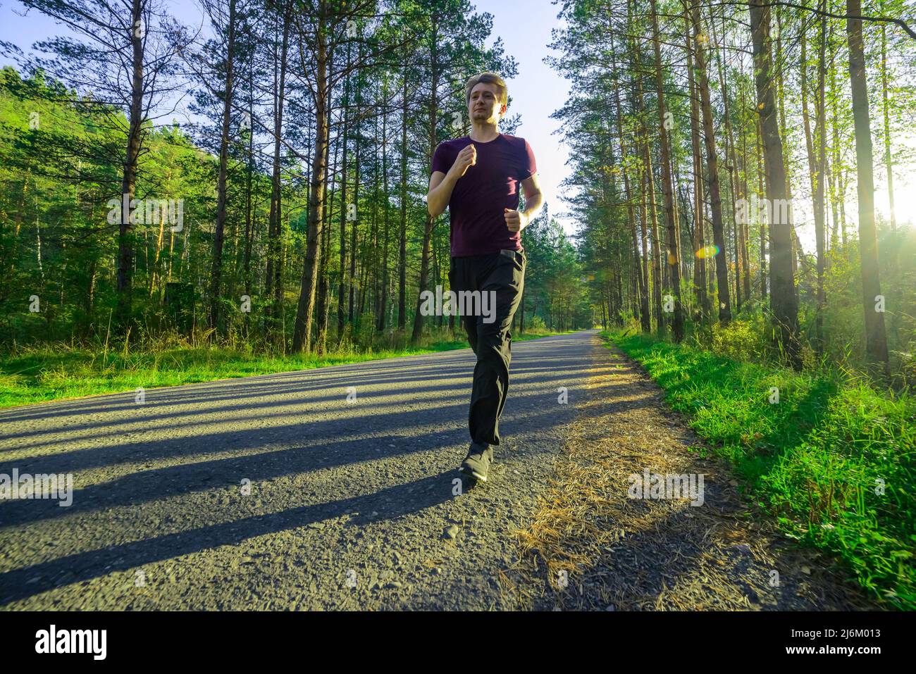 Running man jogging in city park at beautiful summer day. Sport fitness ...