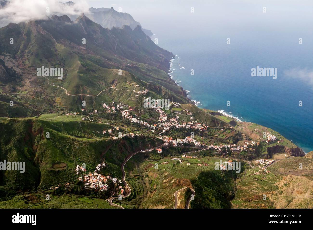 Green mountain valley near the ocean with white houses and roads Stock ...
