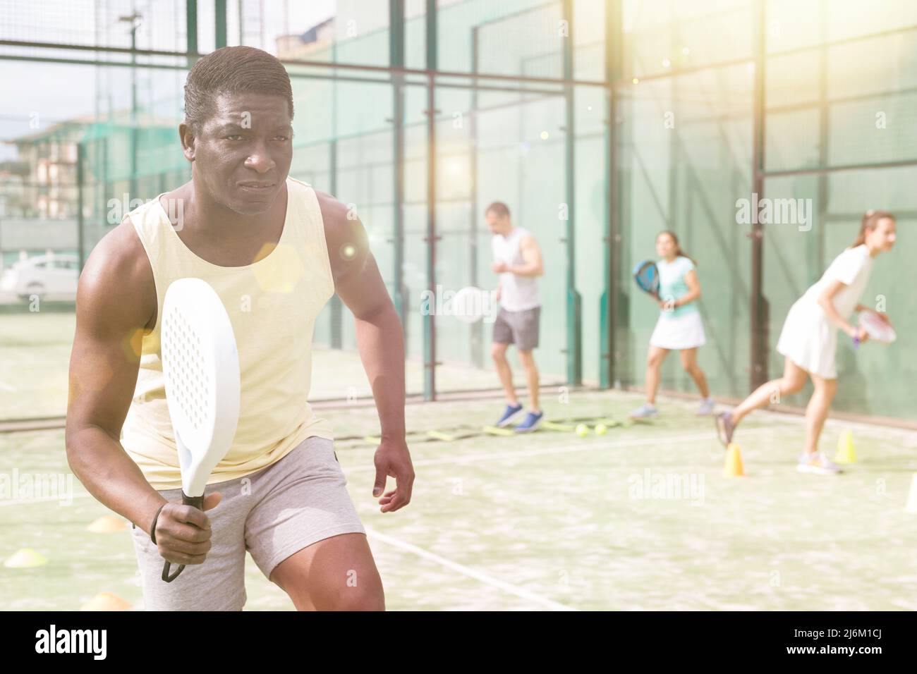 African american man and his female partner playing paddle tennis on ...