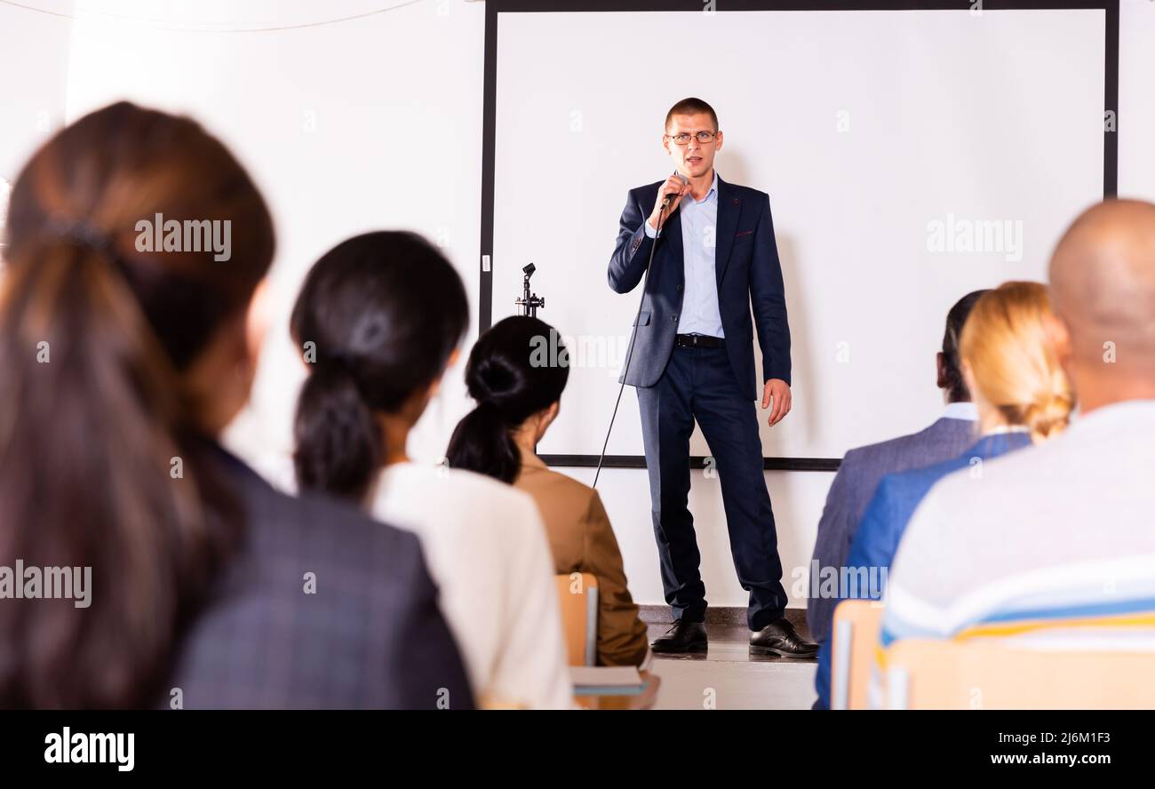Male coach giving speech at conference hall Stock Photo - Alamy