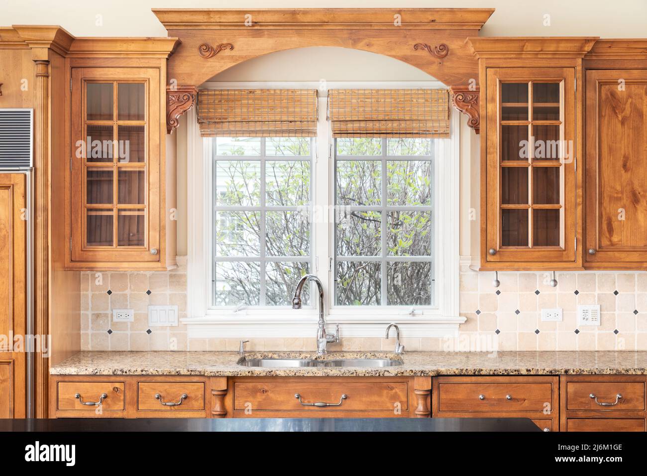 A luxury kitchen detail shot with wood cabinets and granite countertops ...