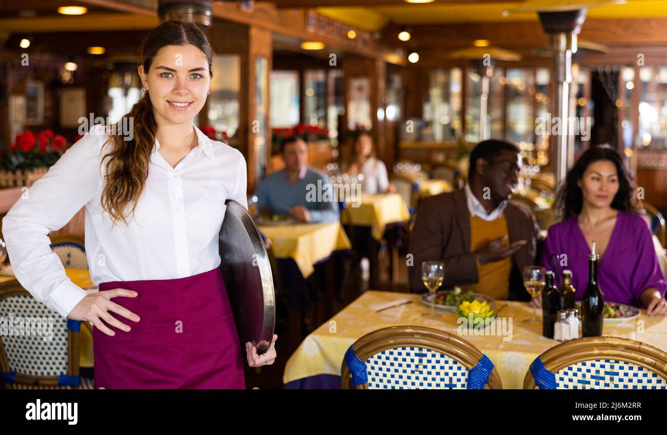 Portrait of young waitress standing in restaurant Stock Photo - Alamy