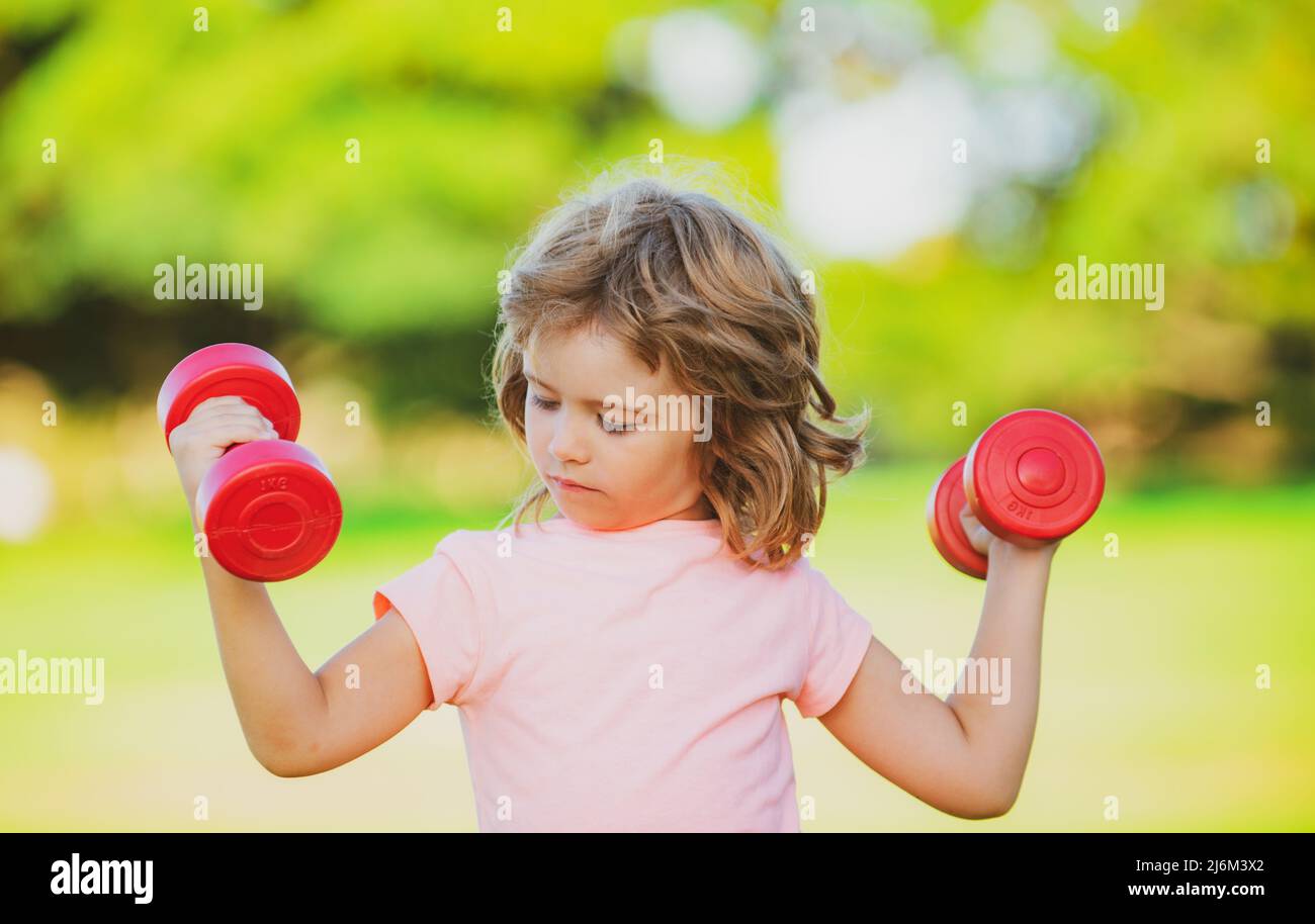 Kid exercising in park. Active boy, healthy lifestyle. Sport child with strong biceps muscles ...