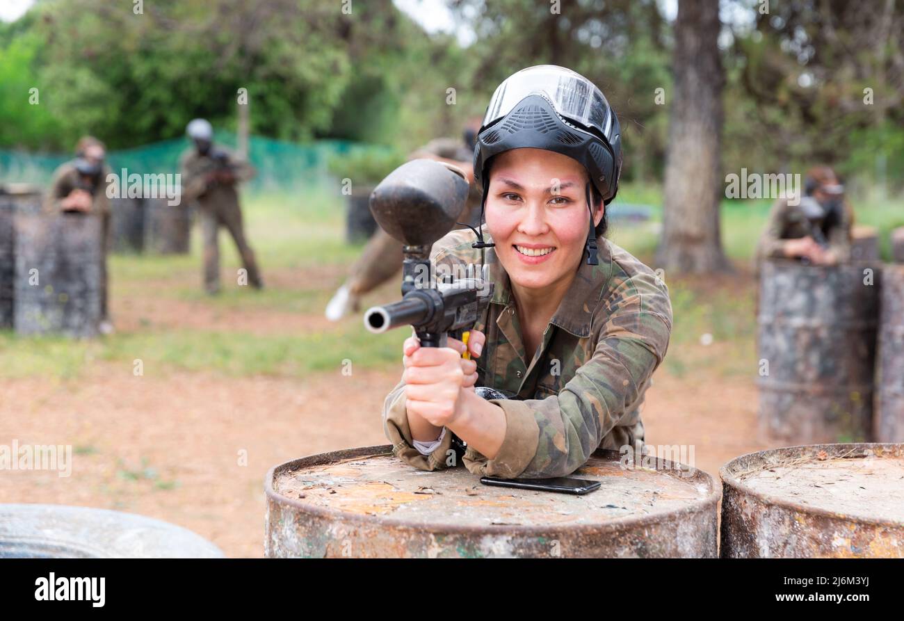 Happy woman wearing uniform and holding gun ready for playing with ...