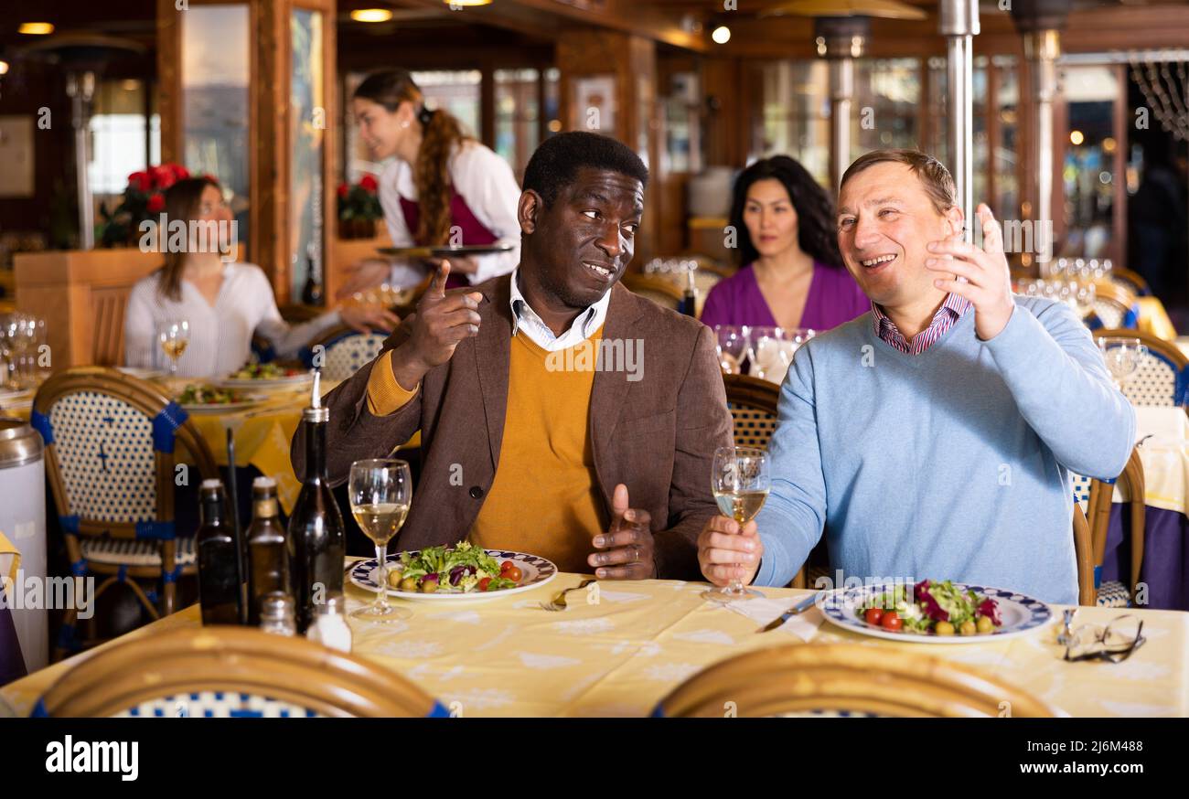Meeting of two cheerful friends at dinner in restaurant Stock Photo - Alamy