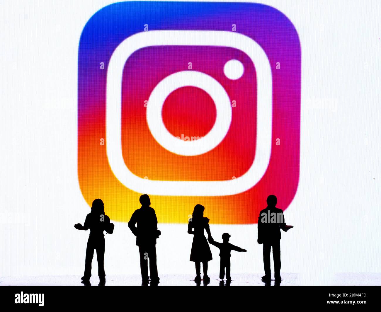 Miniature figures standing in front of an Instagram logo on the ...