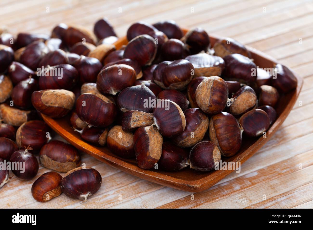 Unpeeled edible sweet chestnuts on wooden background Stock Photo - Alamy
