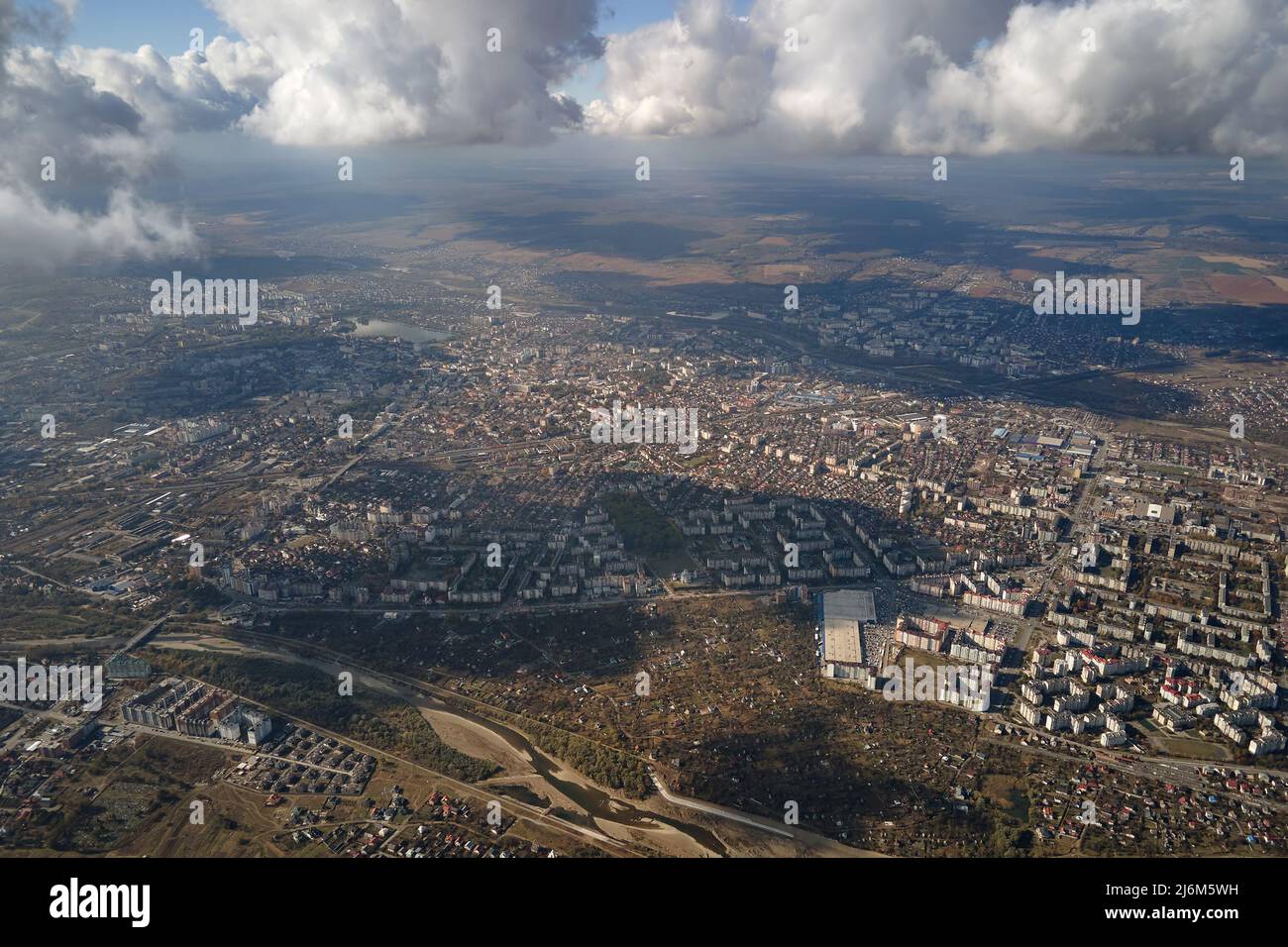 Aerial view from airplane window at high altitude of distant city ...