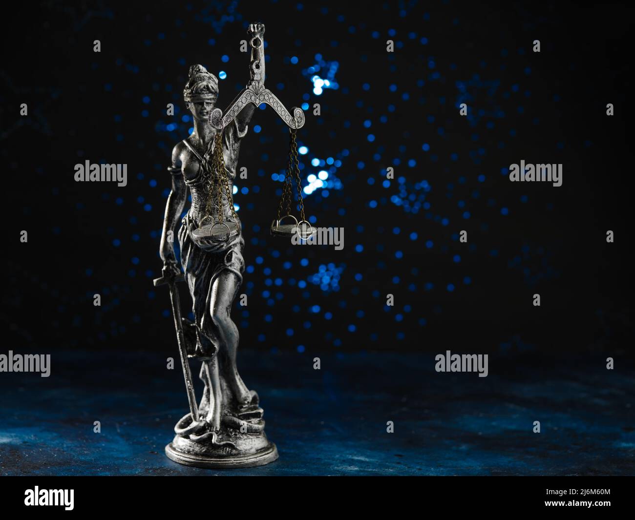 Bronze statuette of the goddess of justice Themis on a dark blue ...