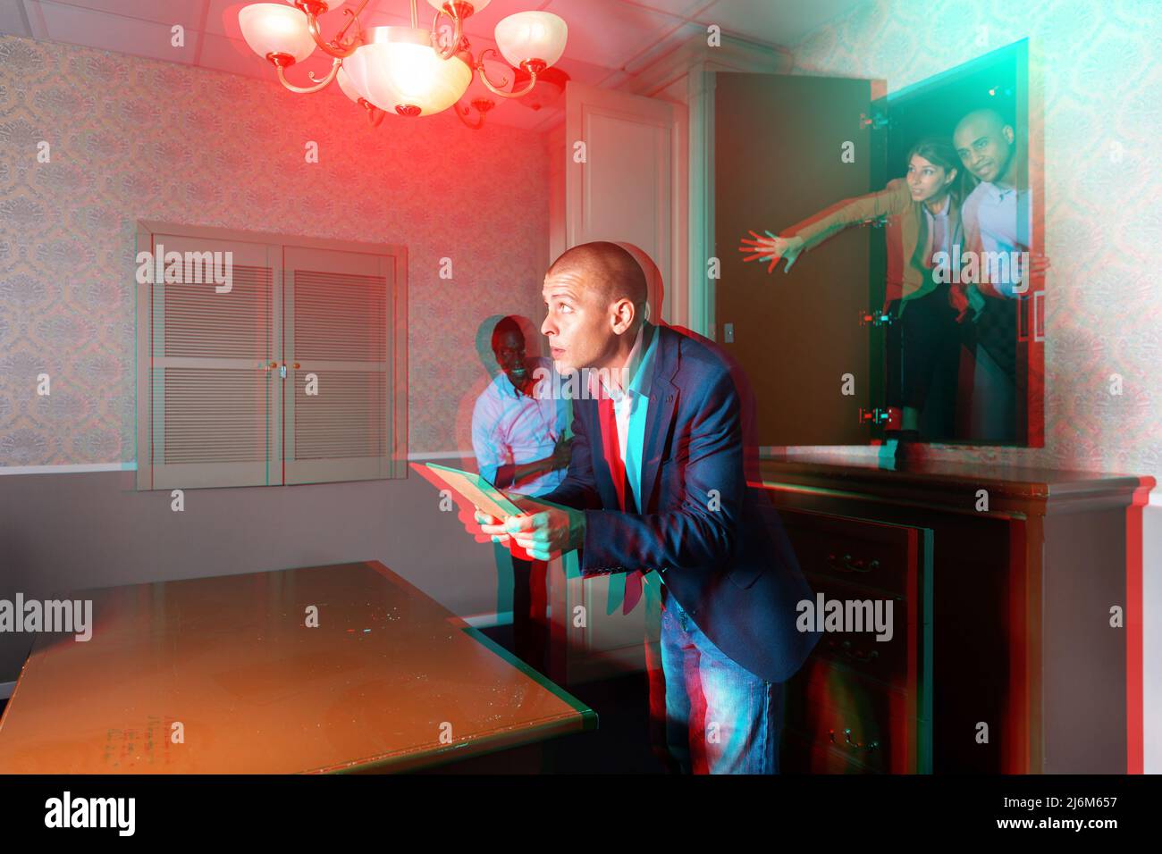 Four friends in quest room with special light effects Stock Photo - Alamy