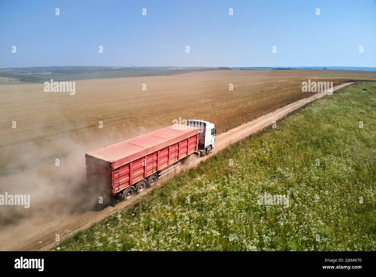 Aerial view of lorry cargo truck driving on dirt road between ...