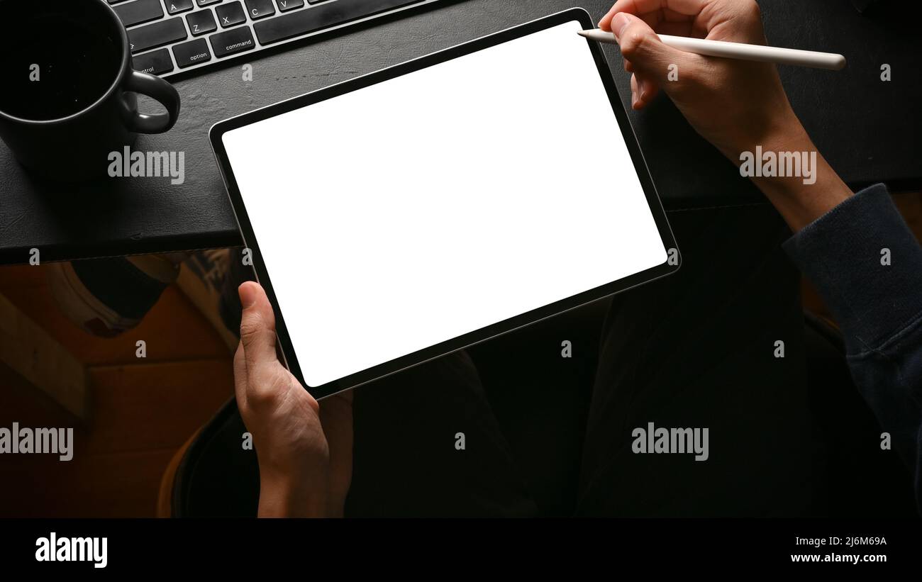 Overhead, A man using digital tablet touchpad at his modern office desk ...