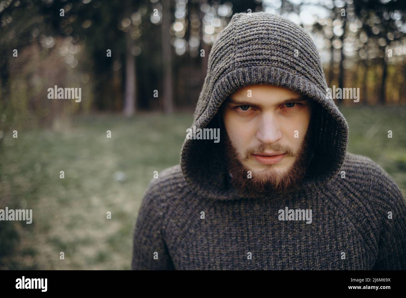 Macho with beard in hood on sunny day. Bearded man wear casual ...