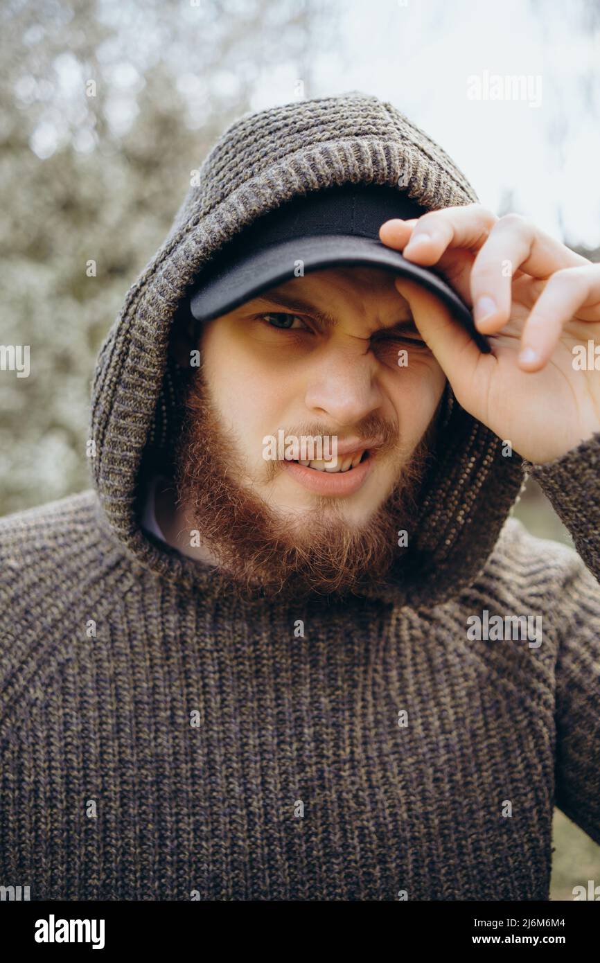 Headshot of a man wearing a brown hooded top with an intense stare at ...