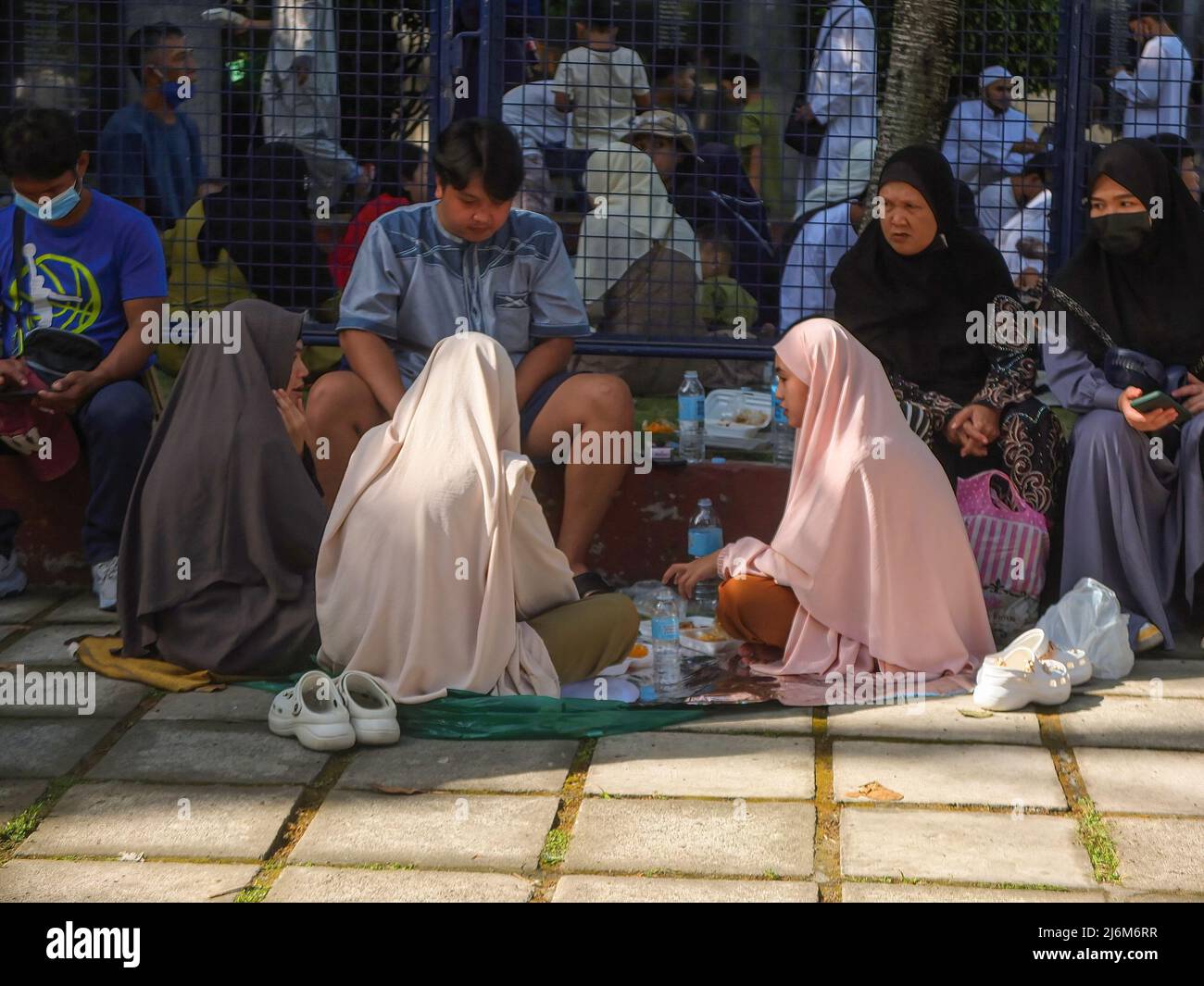 Two Muslim girls enjoy their food with their family. The Muslim ...