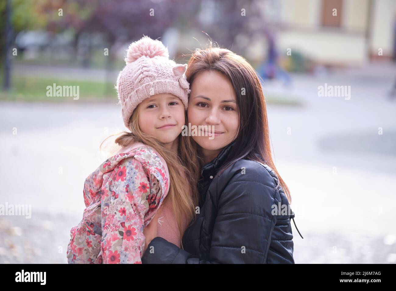 Young pretty woman hugging lovingly her child daughter. Happiness in family relations concept ...