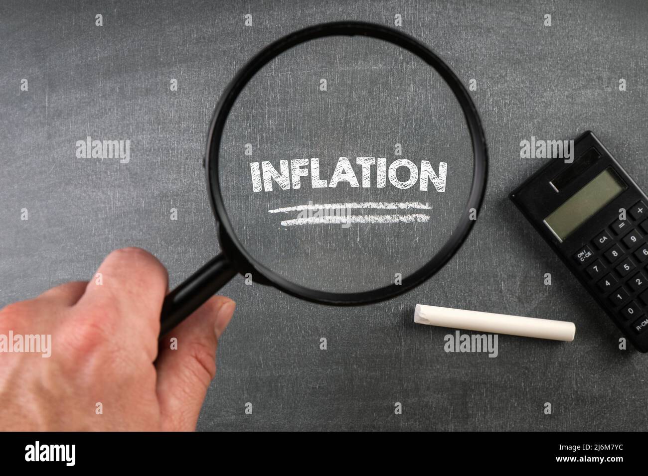 Inflation. Calculator and magnifying glass on a chalkboard background ...