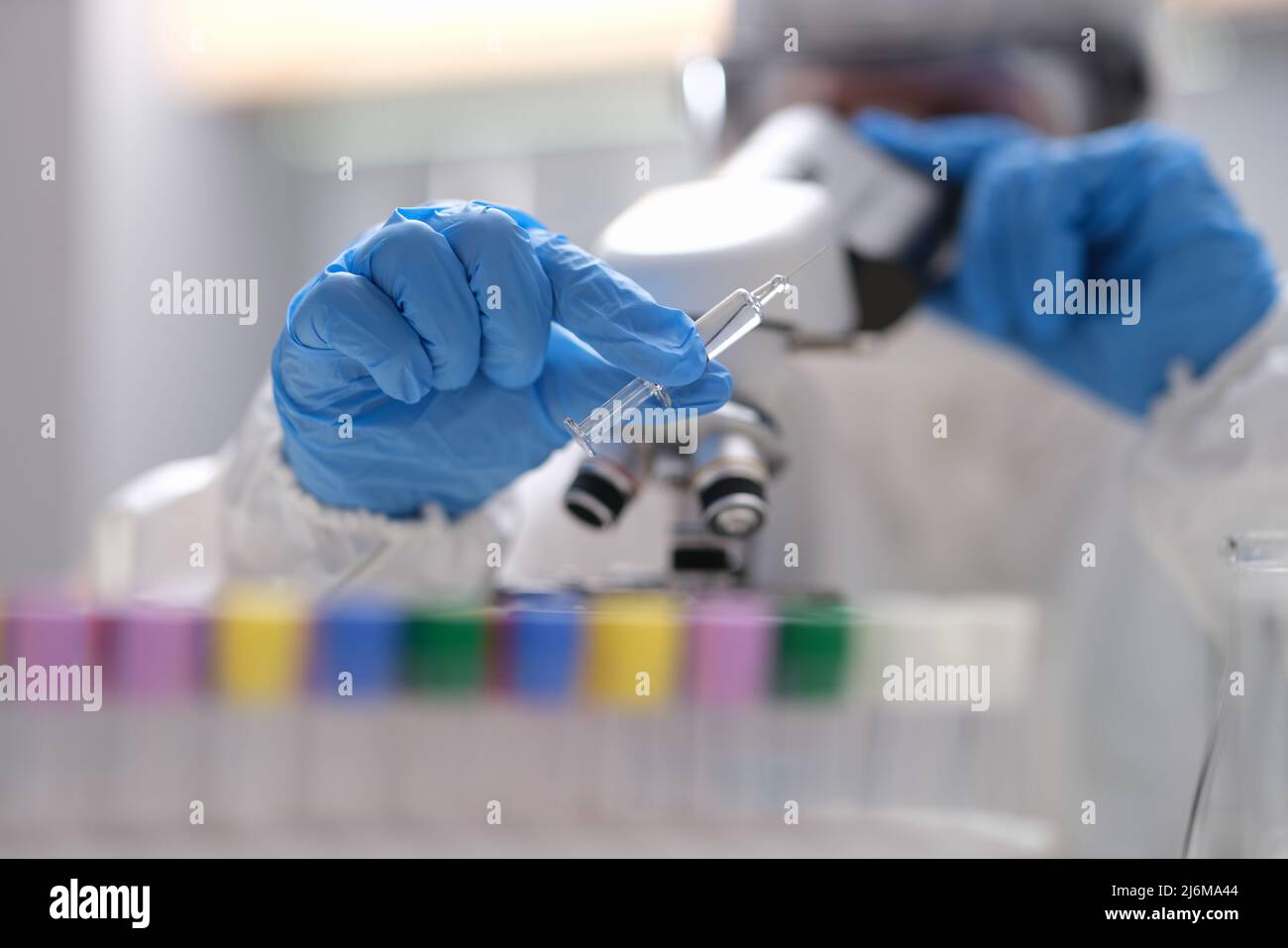 Scientist in laboratory holding syringe with liquid vaccines Stock ...