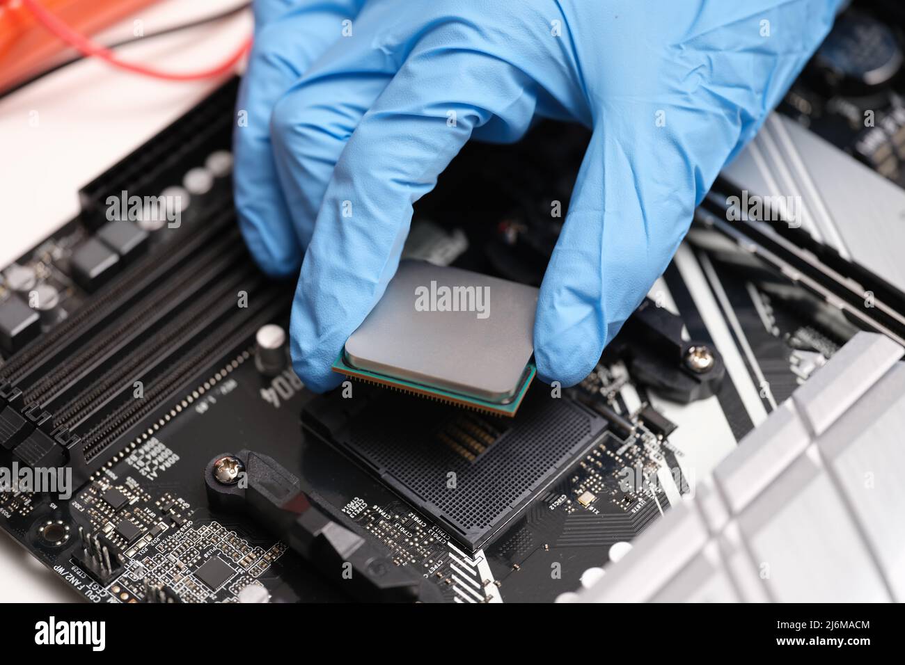 Engineer hand sets the processor to the motherboard Stock Photo - Alamy