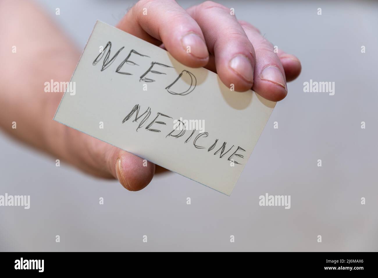 Need medicine. Words written in jagged letters. A man's hand holds a ...