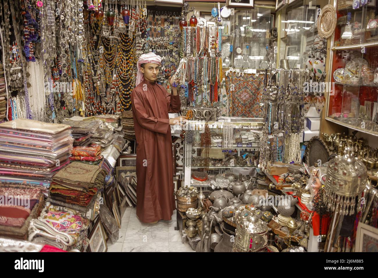 A young Arab man selling curios in a shop in Sharjah's Heritage Area ...