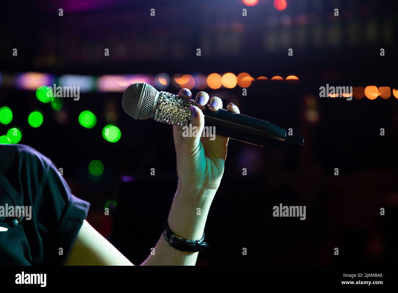 Wireless microphone with rhinestones in woman hand on the night club ...