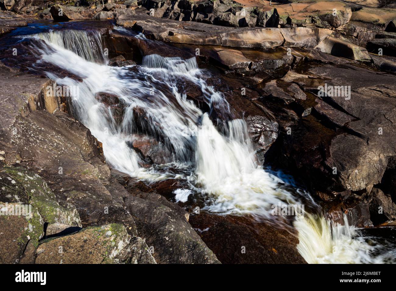 Beautiful waterfall surrounded by rocks and slabs at Reinsfoss in ...