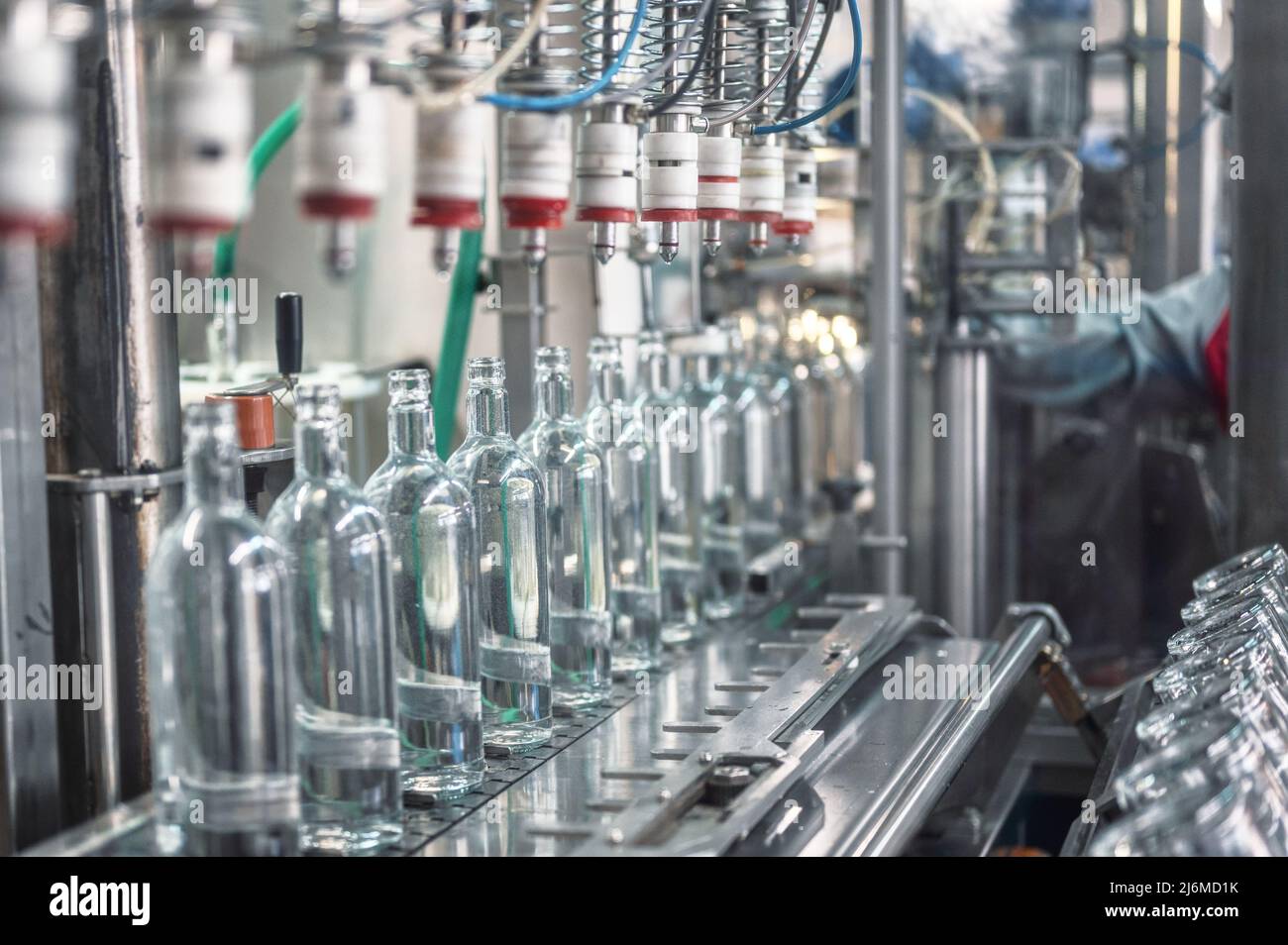 Equipment pours vodka into glass bottles on production line Stock Photo ...
