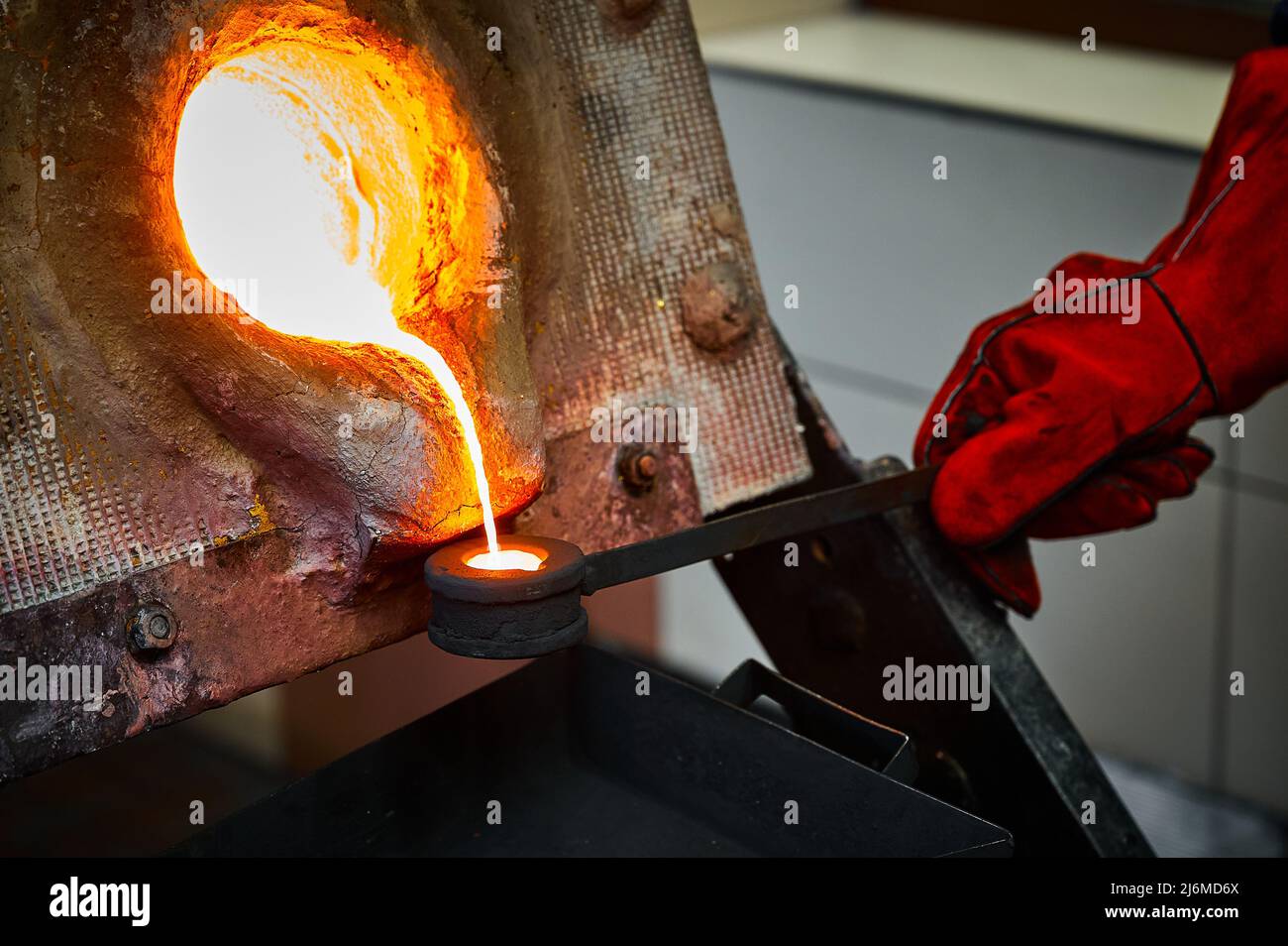 Worker takes sample of liquid gold from furnace for tests Stock Photo ...