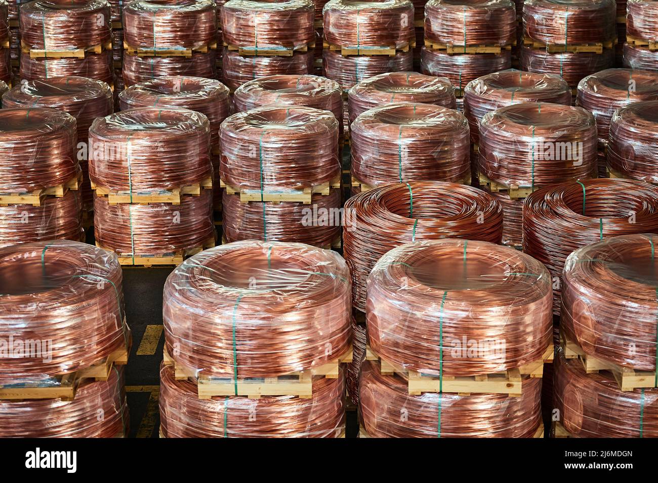 Rows of wrapped copper cable coils in light plant warehouse Stock Photo ...