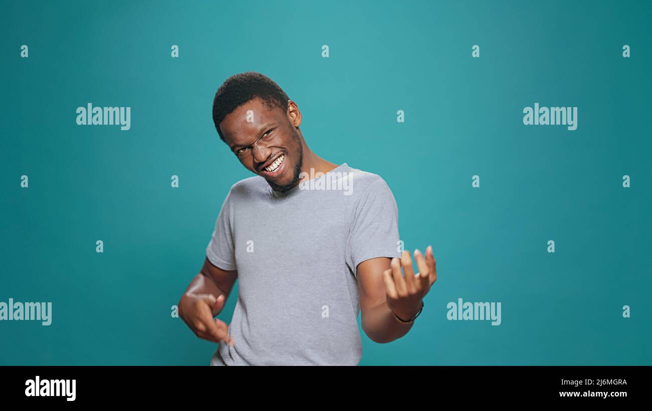 Positive adult doing air guitar performance in front of camera, playing ...