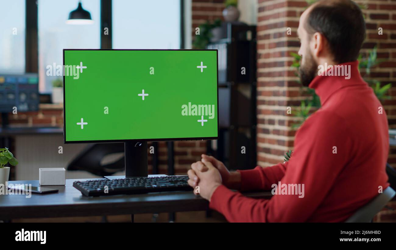 Male employee working with green screen on monitor, using technology at ...