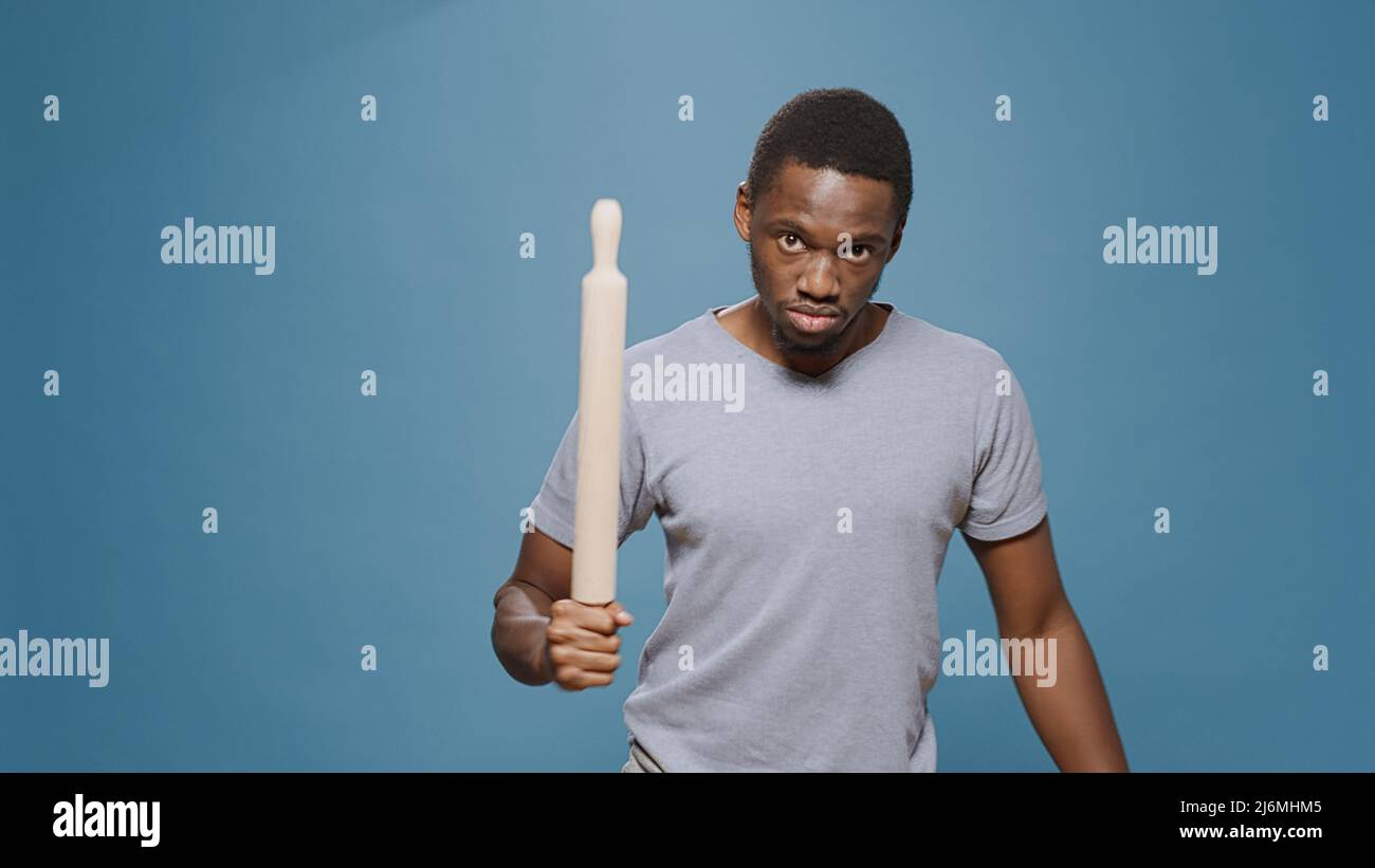 Aggressive upset rebel raising paddle at camera to fight, instigating ...