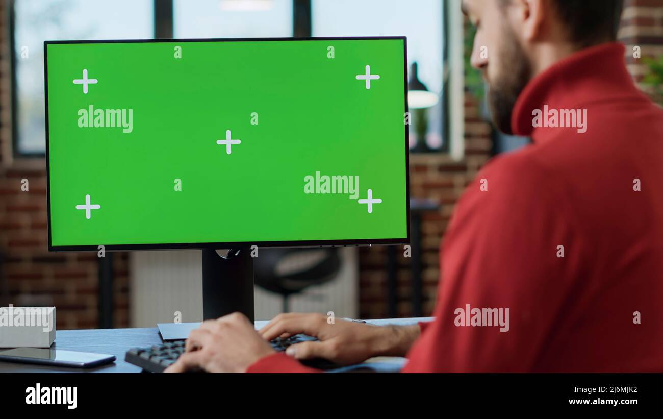Executive manager looking at monitor with green screen, using modern ...