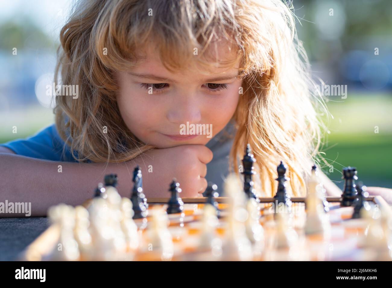 Chess strategy. Close up face of clever smart child. Kid playing chess ...