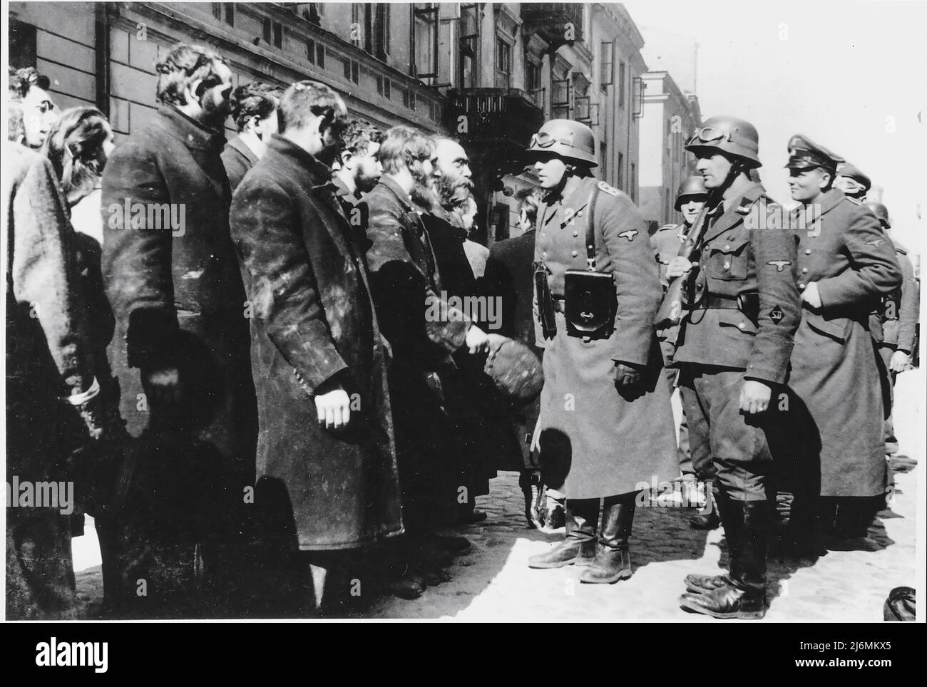 An SS Sergeant (Oberscharfuehrer) interrogates religious Jews captured ...