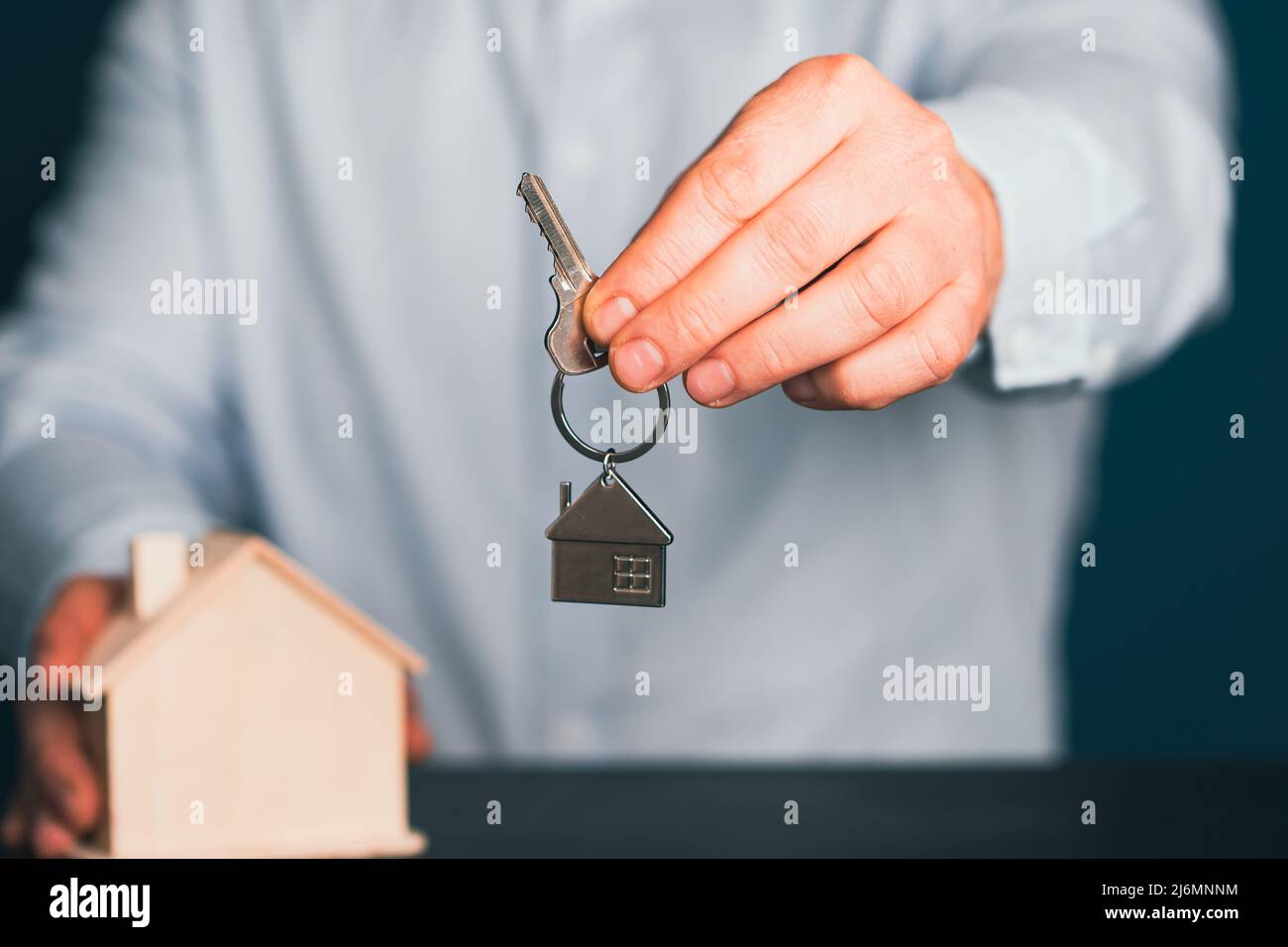 Businessman holding wooden house model and house key.Real estate, home ...