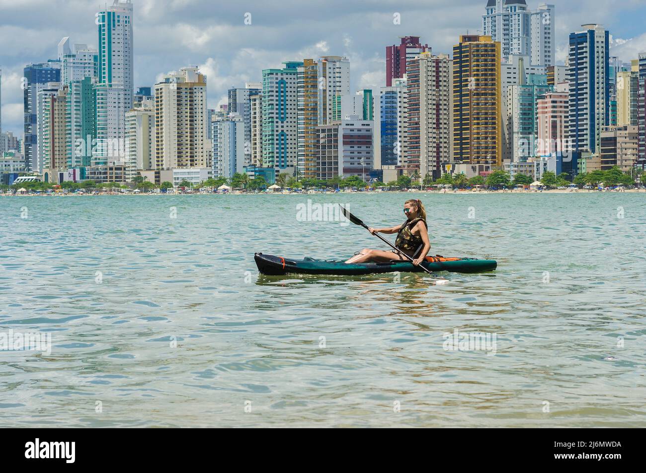 Young woman strolling by kayak on Brazilian beach. Fishing kayak Stock ...