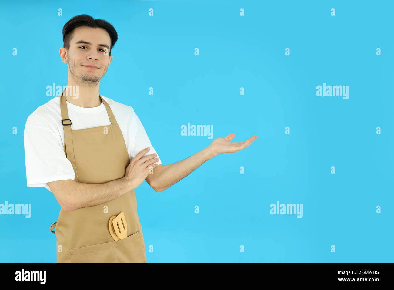 Concept of cooking, young man chef on blue background Stock Photo - Alamy