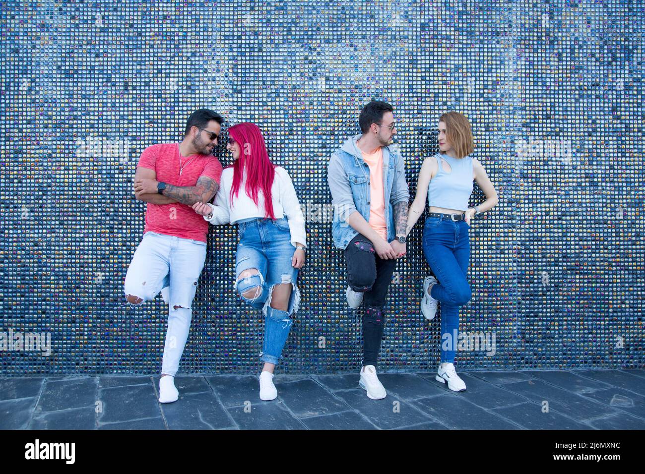 group of four young friends leaning on the wall Stock Photo - Alamy