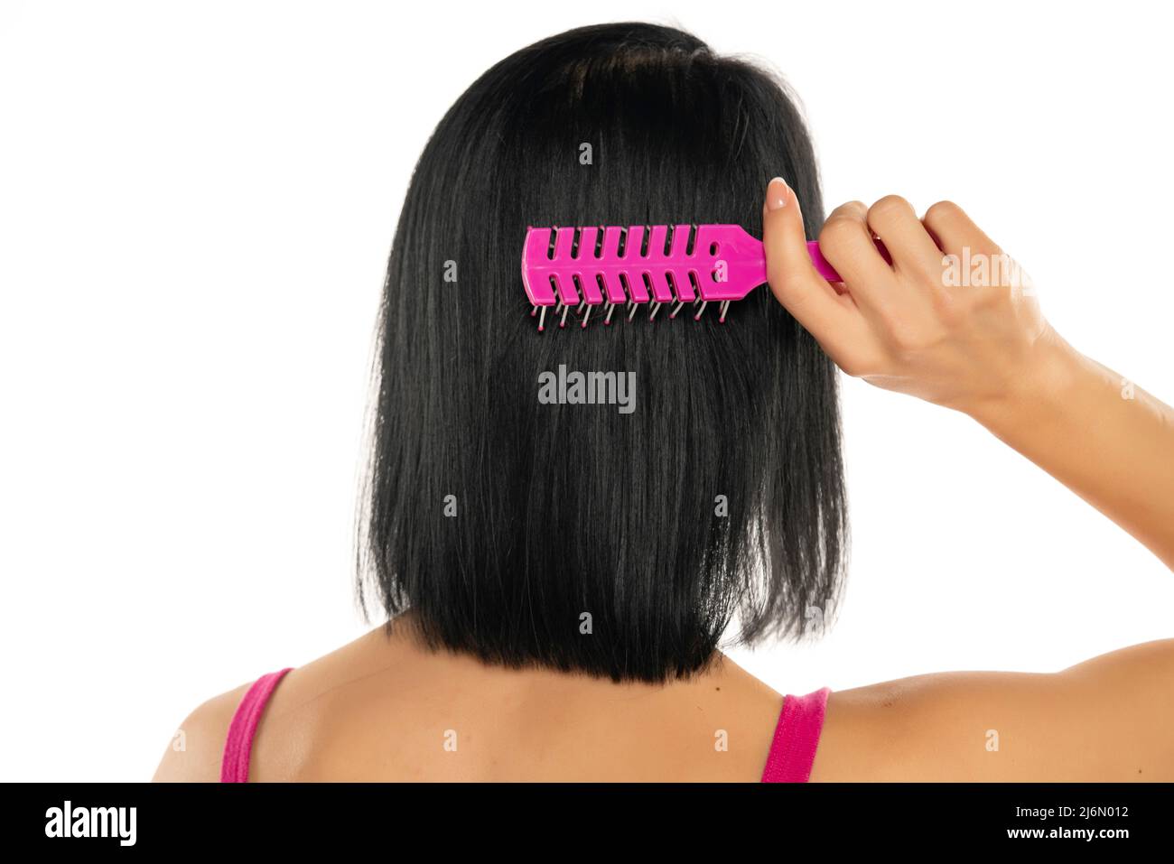 Woman brushing her black straight hair on a white background Stock ...