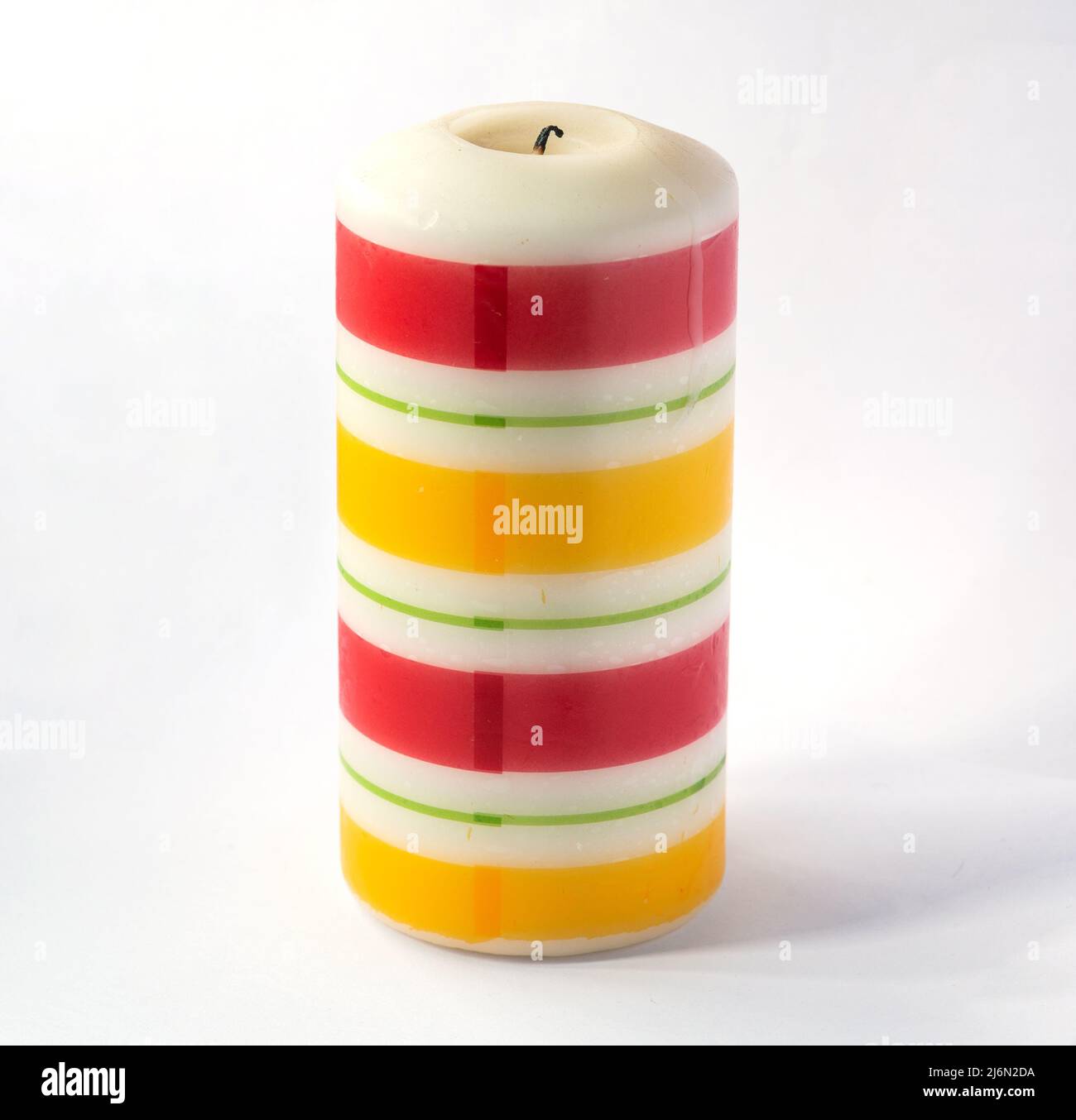 Large thick candle with colored horizontal stripes Isolated on a white ...