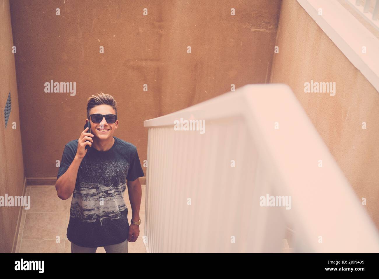 Portrait of young cheerful handsome boy speaking and calling at the ...